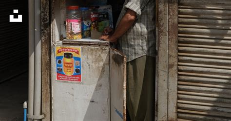 파란색과 흰색 격자 무늬 버튼 업 티셔츠를 입은 남자가 문 근처에 서 있다 사진 Unsplash의 무료 올드 델리 이미지