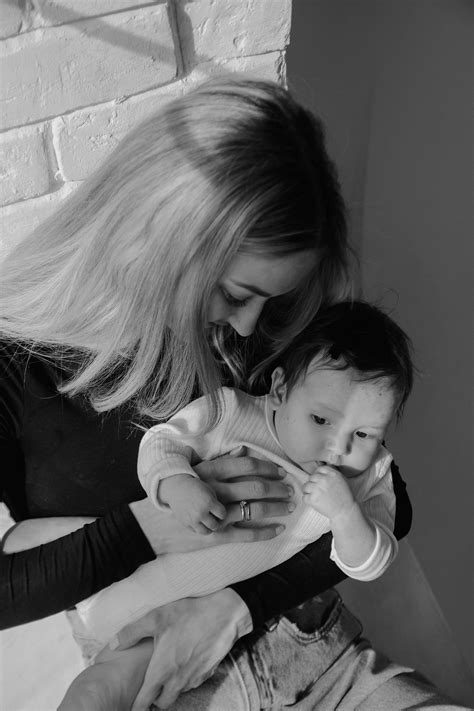 가정의 가족 고요한 관계 귀여운 금발 껴안다 노란색 물방울 무늬 다정함 돌보다 따뜻함 모성 믿음 벽돌 벽 보살피는 보안 봉제완구 부모의 사랑