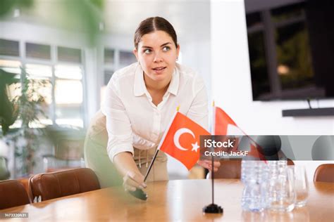 회의실에서 스위스의 국기와 함께 테이블에 터키의 국기를 두는 긍정적인 젊은 여성 20 24세에 대한 스톡 사진 및 기타 이미지 20 24세 British Empire