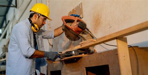 Lower View Of Caucasian Wood Worker Or Carpenter Use Electrical Saw To