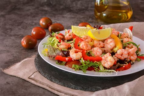 새우 샐러드 후추 퀴 노아 양상추 체리 토마토와 올리브 오일과 레몬 주스가 어두운 배경에 섞여 있습니다 0명에 대한 스톡 사진 및 기타 이미지 Istock