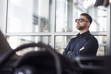 럭셔리 한 모습 자동차 살롱에서 자신의 새로운 차를 시도하는 공식 옷을 입은 남자 검은색에 대한 스톡 사진 및 기타 이미지