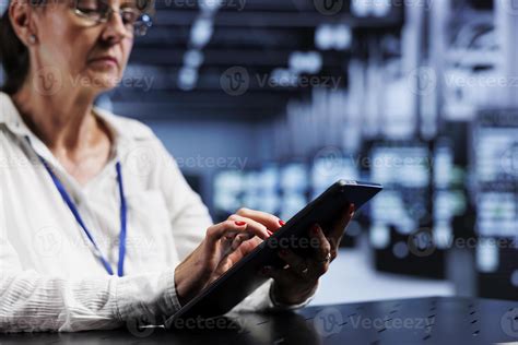 Aged Technical Support Consultant Using Tablet To Assess Server
