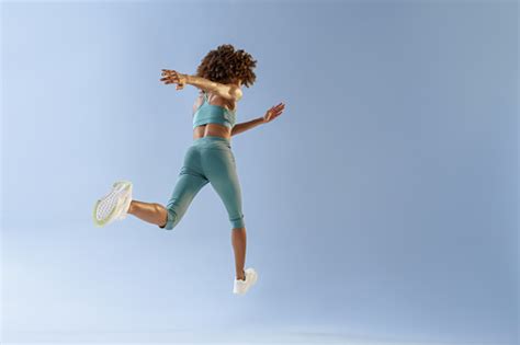 스튜디오 배경 위에 심장 운동 중에 운동하는 공중에서 달리는 스포티한 여성의 뒷모습 점프에 대한 스톡 사진 및 기타 이미지 점프 체육관 컷아웃 Istock