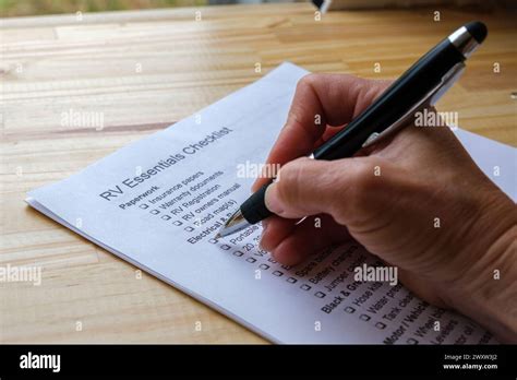hand holding a pen checking off boxes on rv essentials checklist stock