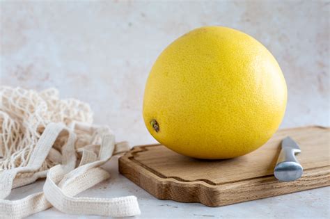 중립적인 배경에 메쉬 백이 있는 나무 도마에 노란색 포멜로 한 개 복사 공간이 있는 수평 0명에 대한 스톡 사진 및 기타 이미지 0명 가방 감귤류 과일 Istock