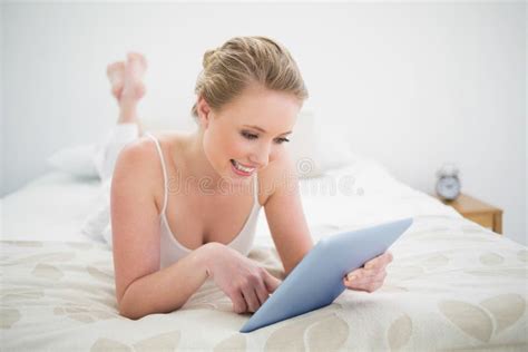 Natural Smiling Blonde Lying On Bed Using Tablet Stock Image Image Of