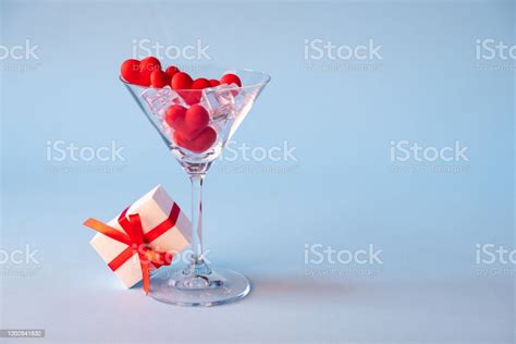 빨간 하트 모양의 설탕 사탕과 얼음과 선물 상자 파란색 배경 유리 사랑을 위한 시간 발렌타인 데이 기념일 또는 결혼 축하 개념입니다 공간을 복사합니다 마티니에 대한 스톡
