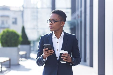 휴대 전화를 사용하는 비즈니스 여성 사무실 밖에서 심각한 아프리카 계 미국인 노동자 멀리 떨어진에 대한 스톡 사진 및 기타 이미지 멀리 떨어진 비즈니스 아프리카계
