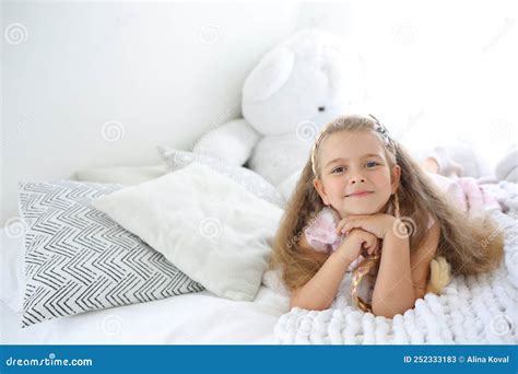 Little Cute Caucasian Girl With A Smile Lying On The Bed Stock Image