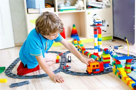 사랑 스러운 작은 금발 아이가 소년 다채로운 플라스틱 블록으로 고 역을 만들기 어린이 건물 철도 장난감 가정에서 함께 재미 6 7 살에 대한 스톡 사진 및 기타 이미지