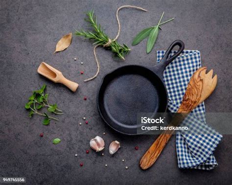 어두운 돌 배경에 빈 오래 된 무 쇠 Skille 스테이크 개념 복사 공간을 만들기 위한 재료입니다 각종 허브와 양념 로즈마리 세이 지 베이 잎 바 질 마늘 및 후추의 열매