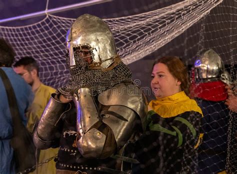 Squire In Medieval Clothing Helps Knight Put On His Armor At Spring
