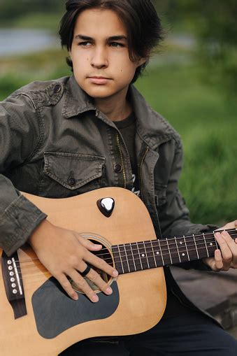 야외에서 기타를 연주 잘 생긴 십대 소년의 초상화 클래식 기타를 사용하는 소년 남성 혼자 음악을 만들기 귀여운에 대한 스톡 사진 및 기타 이미지 Istock
