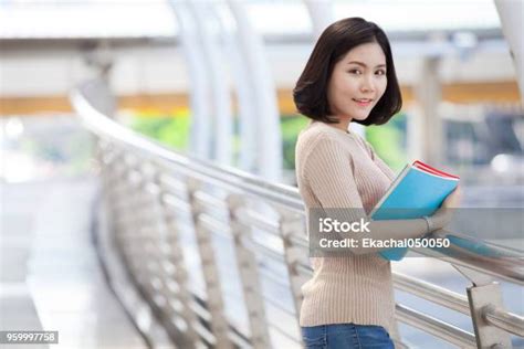 아름 다운 아시아 여성 대학생 야외 서 행복 하 게 웃는 그녀의 책을 들고 고등학교 프로그램 스마트 십 대 개념을 학습 하는