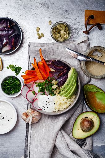 신선한 건강 한 채식 슬라이스 아보카도 Coucous 및 빨간 양파 구운된 당근 점심 그릇 간단 하 고 다채로운 유기농 식품 개념입니다 평면 복사 공간을 놓으십시오 0명에