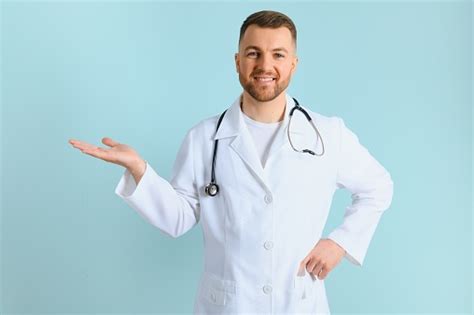 왼쪽에 복사 공간이있는 파란색 배경에 고립 된 손으로 무언가를 보여주고 제시하는 젊은 남성 의사의 수평 배너 남자에 대한 스톡 사진 및 기타 이미지 Istock