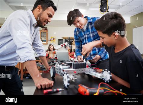 Teacher With Male Pupils Building Robotic Vehicle In Science Lesson Stock Photo Alamy