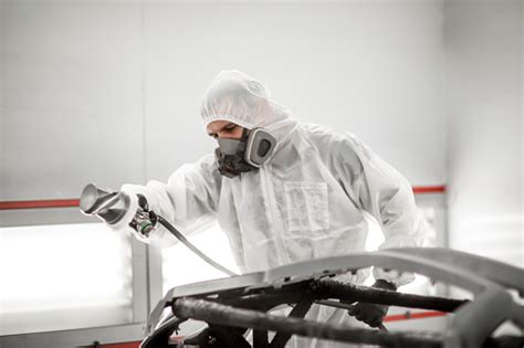 페인팅 부스의 자동차 부품에 페인트 코트를 적용 한 전체 작업복과 호흡 마스크의 차체 공장 기술자 가스 압축기에 대한 스톡 사진