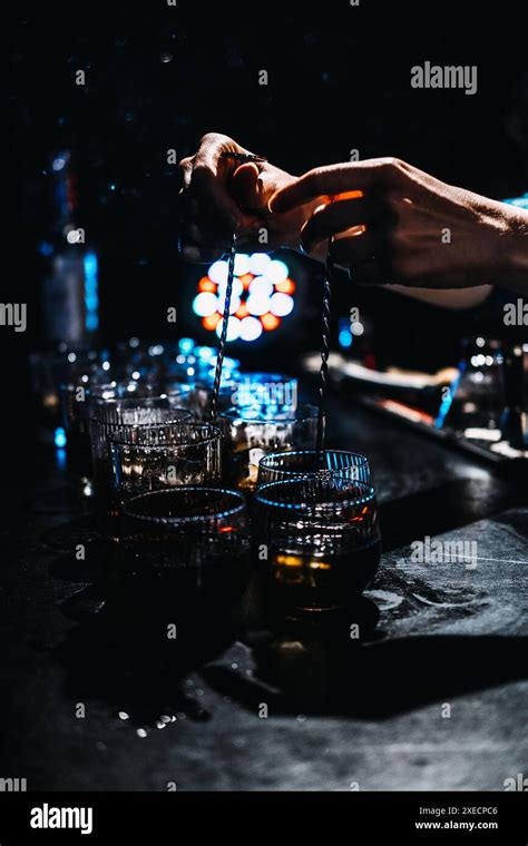 bartender preparing multiple coffee whiskey cocktails at a busy bar