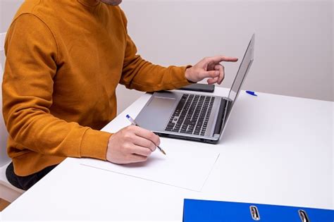 종이에 무언가를 쓰기 위해 펜을 들고 노트북 앞에 앉아있는 한 남자의 샷 금융에 대한 스톡 사진 및 기타 이미지 금융 기업 비즈니스 노트북 Istock