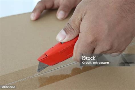 날카로운 칼을 사용하여 종이 소포를 열고 조심스럽게 배송 상자를 개봉하는 남자의 손 클로즈업 이미지 35 39세에 대한 스톡 사진 및 기타 이미지 Istock