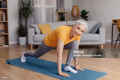 그녀의 다리를 뻗는 운동 나이 든 여자 집에서 운동에 러너의 런지 요가 자세를 취 거실에서 운동 60 64세에 대한 스톡 사진 및 기타 이미지 Istock