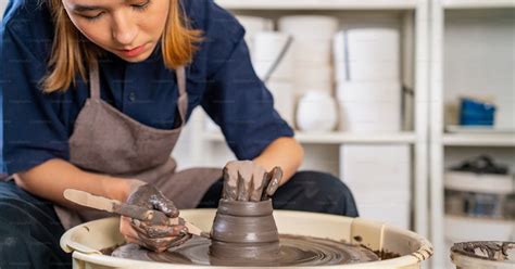 아름 다운 아시아 여성 조각가 예술가는 세라믹 스튜디오에서 도자기 바퀴에 점토를 조각합니다 생 점토를 성형하는 여성 장인은