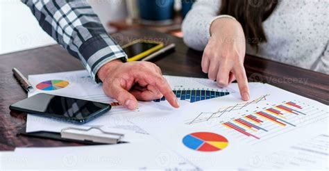 Two Businesspeople Analyzing Graphs Without Faces Analyzing Data With
