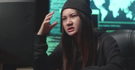 Young Asian Woman Hacker Using Computer Hacking And Upset Code On Multiple Computer Screens