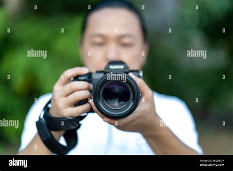 asian man holds the medium format camera in his hand and focus to shoot