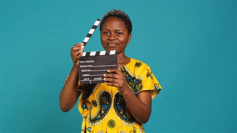 Female Film Producer Using A Clapperboard To Say Action In Movie