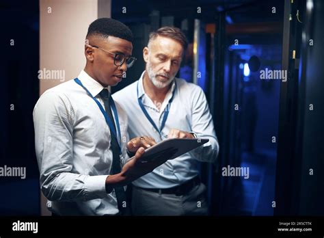 Updating Every System In The Room Two Technicians Using A Digital Tablet While Working In A