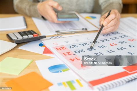 집에서 스마트 폰을 사용하고 이벤트 계획 일정 조직 청구서 지불 마감일 목표 시간 관리 생산성 및 작업 관리를 위해 캘린더에 쓰는 사업가 달력에 대한 스톡 사진 및 기타