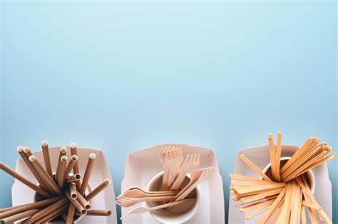 종이 컵 접시 가방 나무 포크 음주 빨대 패스트 푸드 용기 밝은 파란색 배경에 나무 칼붙이 에코 크래프트 종이 식기 재활용 및 음식 배달 개념 모의 위쪽 보기 재활용에 대한