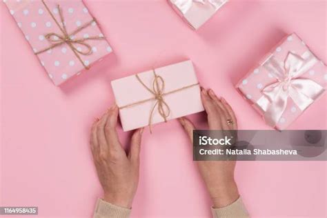 분홍색 파스텔 테이블 상단보기에 선물 또는 선물 상자를 들고 여성 손 생일이나 새해를 위해 평평하게 누워 있습니다 갈색에 대한 스톡 사진 및 기타 이미지 Istock