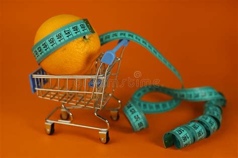 on a bright orange background a blue sewing centimeter and a juicy