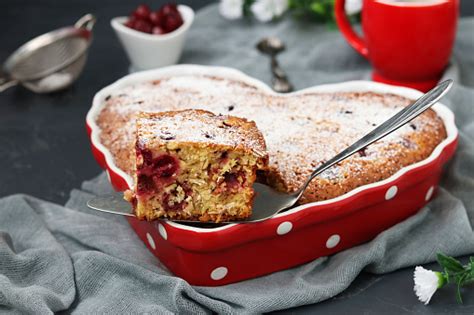 체리가 있는 오트밀 파이 케이크 한 조각을 잘라내고 어두운 배경에 하트 모양의 세라믹 모양의 가루 설탕을 뿌린 다 0명에 대한 스톡 사진 및 기타 이미지 Istock