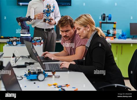 A Group Of Colleagues Working Together In A Robotics Laboratory