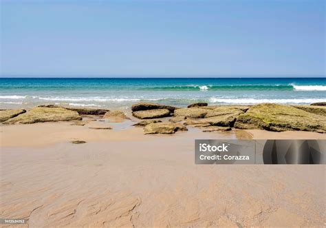 스페인 카디스 해안의 그림 같은 해변 풍경 오렌지 모래 파도와 거품이있는 청록색 바다 맑은 하늘 휴가 여름 휴식 0명에 대한 스톡 사진 및 기타 이미지 Istock