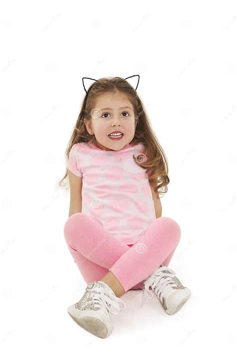 Портрет милой девушки сидя на поле смотря вверх Стоковое Изображение