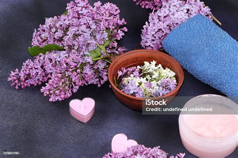 어두운 배경에 나무 그릇에 라일락 꽃에서 향기로운 물로 스파와 웰빙 구성 아로마 테라피와 피부와 바디 케어 플랫 레이 라이프