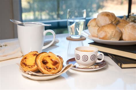 파스 테이스 데 나타 포르투갈 요리의 전통적인 달콤한 작은 바삭 바삭한 퍼프 페이스 트리 파이와 계란으로 만든 크림 종종 맛보고 커피와 함께합니다 아침 식사 테이블 세트 0