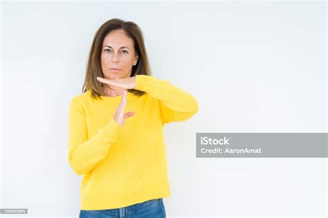 아름 다운 중간 나이 여자는 고립 된 배경 위에 노란 스웨터를 입고 손 좌절 하 고 심각한 얼굴 제스처 시간을 갈색 머리에 대한 스톡 사진 및 기타 이미지 Istock