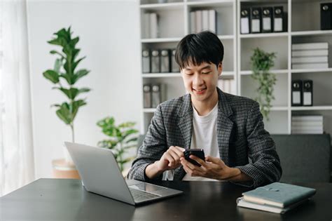 젊은 사업가는 노트북 태블릿을 들고 현대적인 사무실에서 일하고 종이에 메모를 하고 있다 20 24세에 대한 스톡 사진 및 기타 이미지 20 24세 가상현실 남성