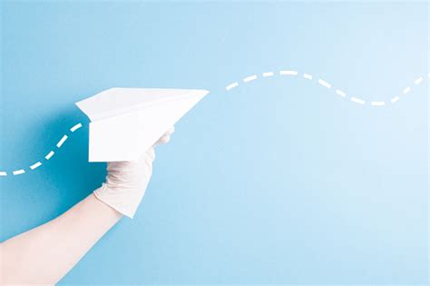 흰색 고무 장갑에 손을 잡고 밝은 파란색 배경에 종이 비행기를 보유하고 공간을 복사 코로나 바이러스 전염병 개념으로 인한 수혈 금지 0명에 대한 스톡 사진 및 기타 이미지