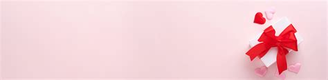 분홍색 배경에 빨간 리본과 작은 빨간 장식 하트흰색 선물 상자 복사 공간이 있는 상단 뷰입니다 발렌타인 데이 또는 결혼식 로맨틱
