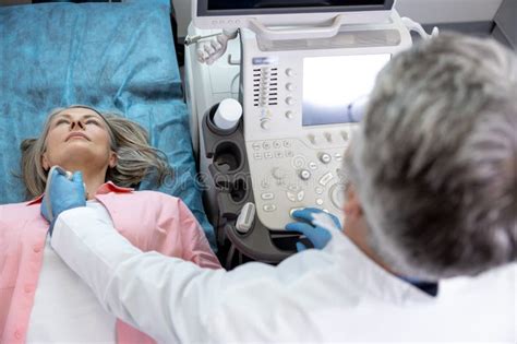 Doctor Performing Thyroid Gland Ultrasonography To A Female Patient