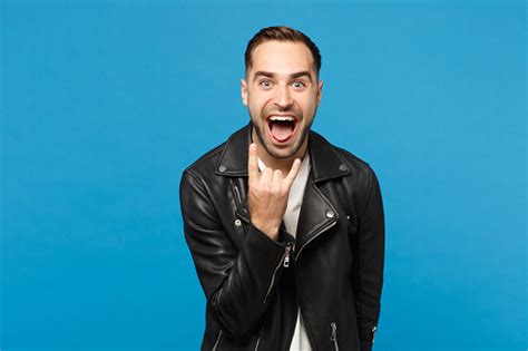 검은 색 가죽 자 켓 흰색 T 셔츠에 잘생긴 세련 된 젊은 이루어지지 남자 블루 벽 배경 스튜디오 초상화에 고립 된 카메라를 찾고 사람들은 진심으로 감정 라이프 스타일