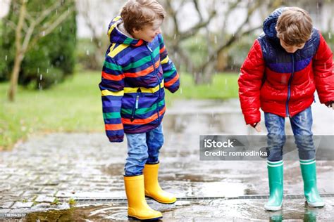 추운 날 진눈깨비 비 눈 속에서 학교에 가는 길에 어린 두 아이 어린이 가장 친한 친구와 형제 다채로운 패션 캐주얼 옷 봄에